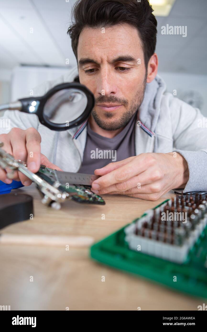 man using plier to assemble printed circuit board Stock Photo - Alamy