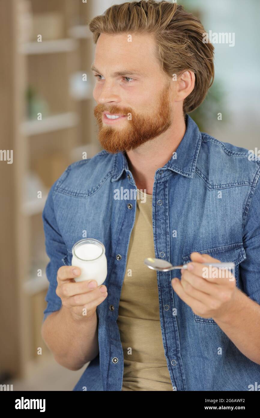 man is eating yogurt Stock Photo - Alamy