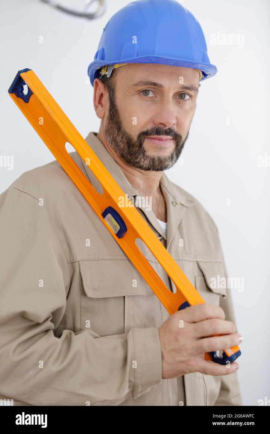 a workman holding orange level Stock Photo - Alamy