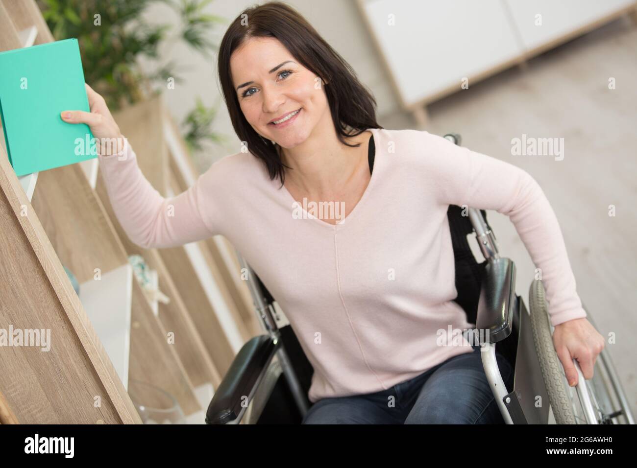 young disabled woman tidying up a book Stock Photo - Alamy