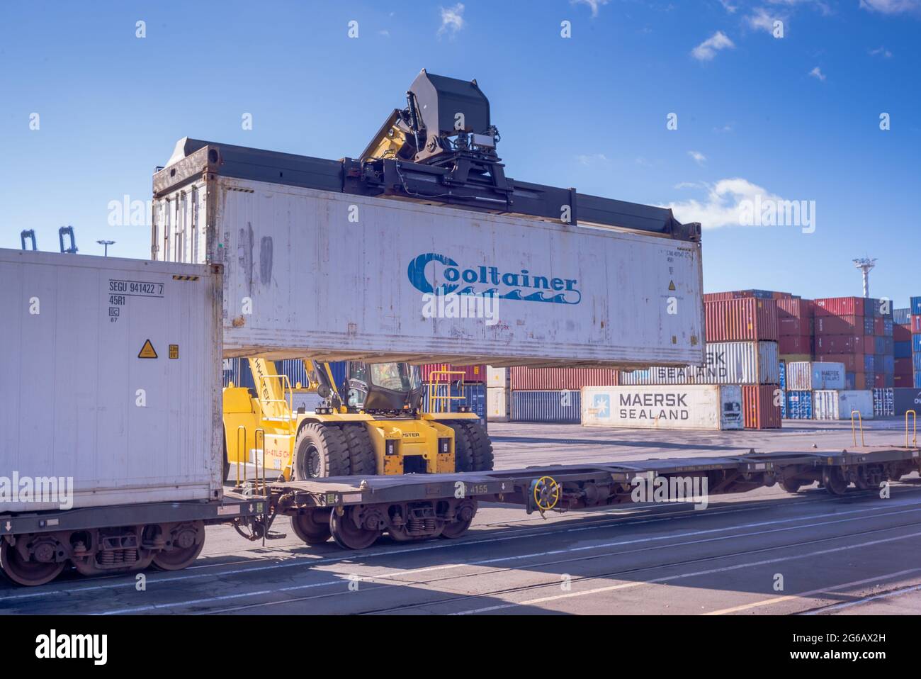 A container crane placing a container of a railway wagon at Ports of ...