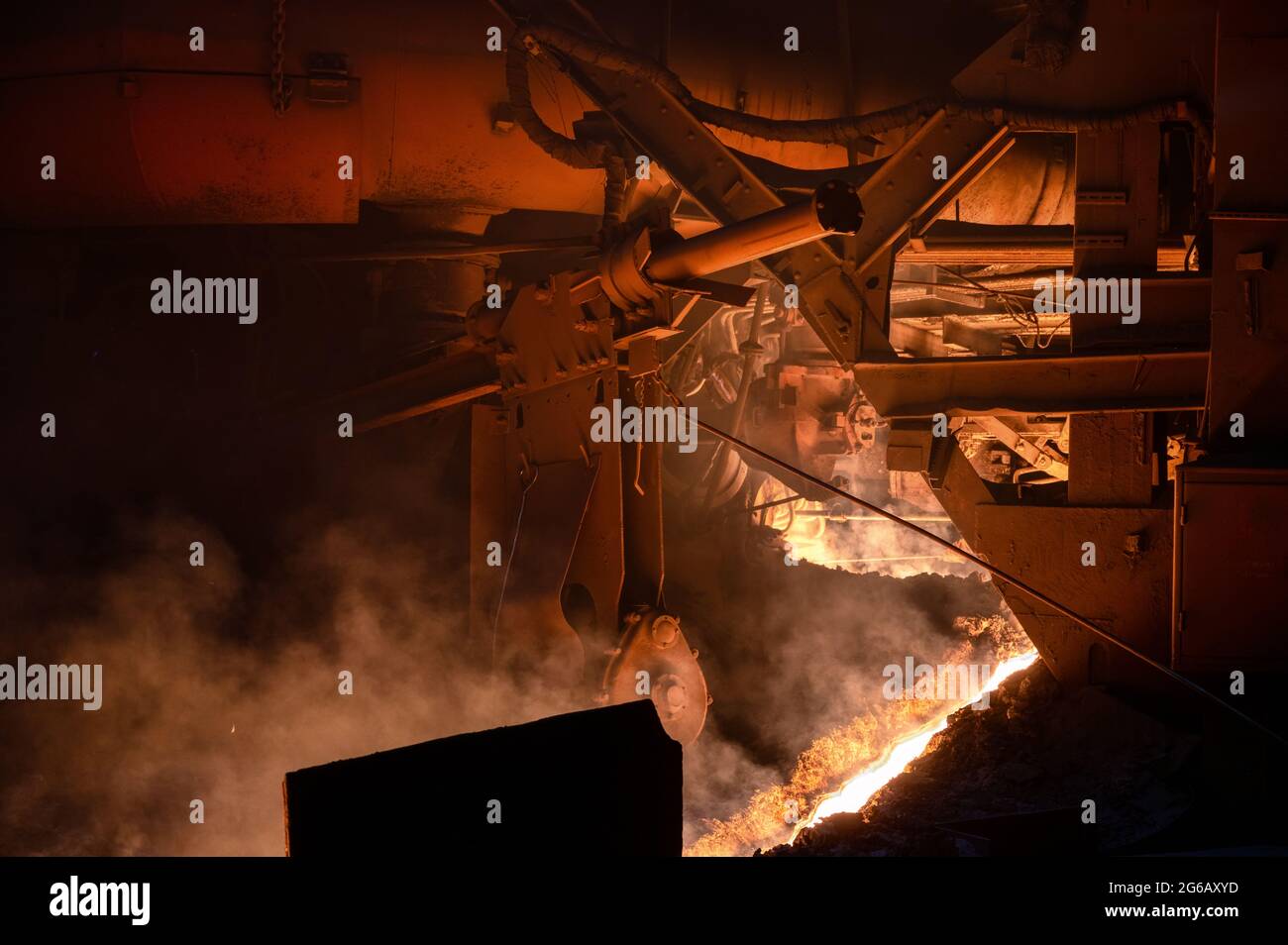 A stream of hot metal, molten steel flowing along a guide chute Stock ...