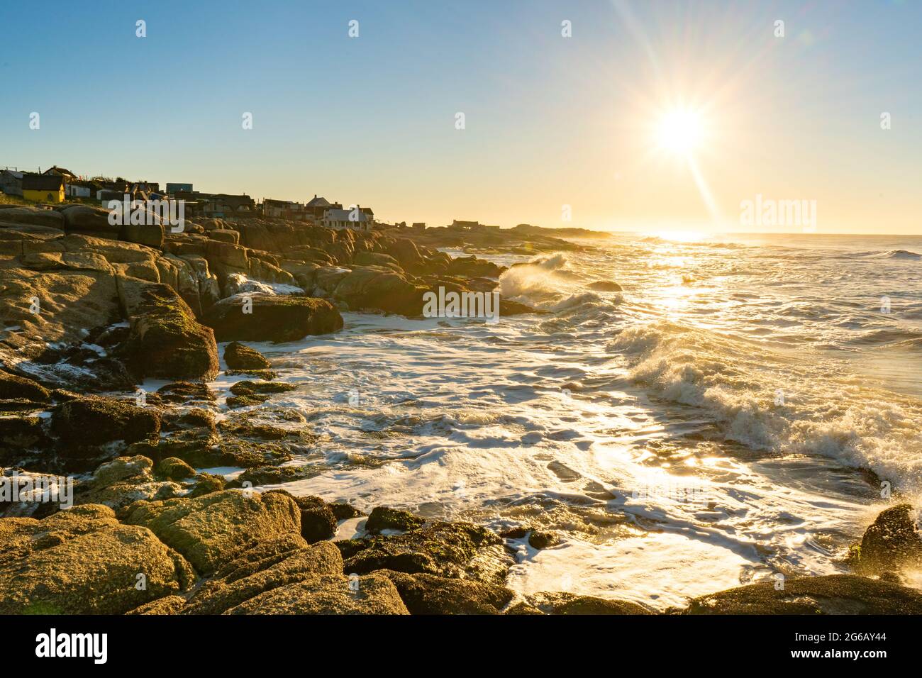 Horizontal wallpaper of foamy ocean waves breaking on a rocky beach ...