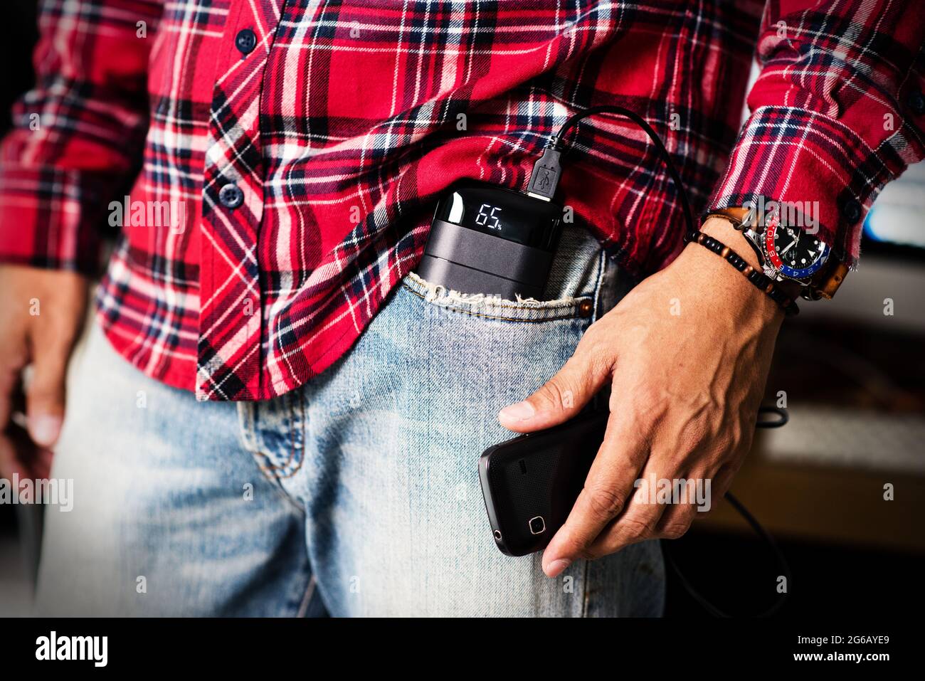 The man charging his smartphone with black power bank. Shallow depth of ...