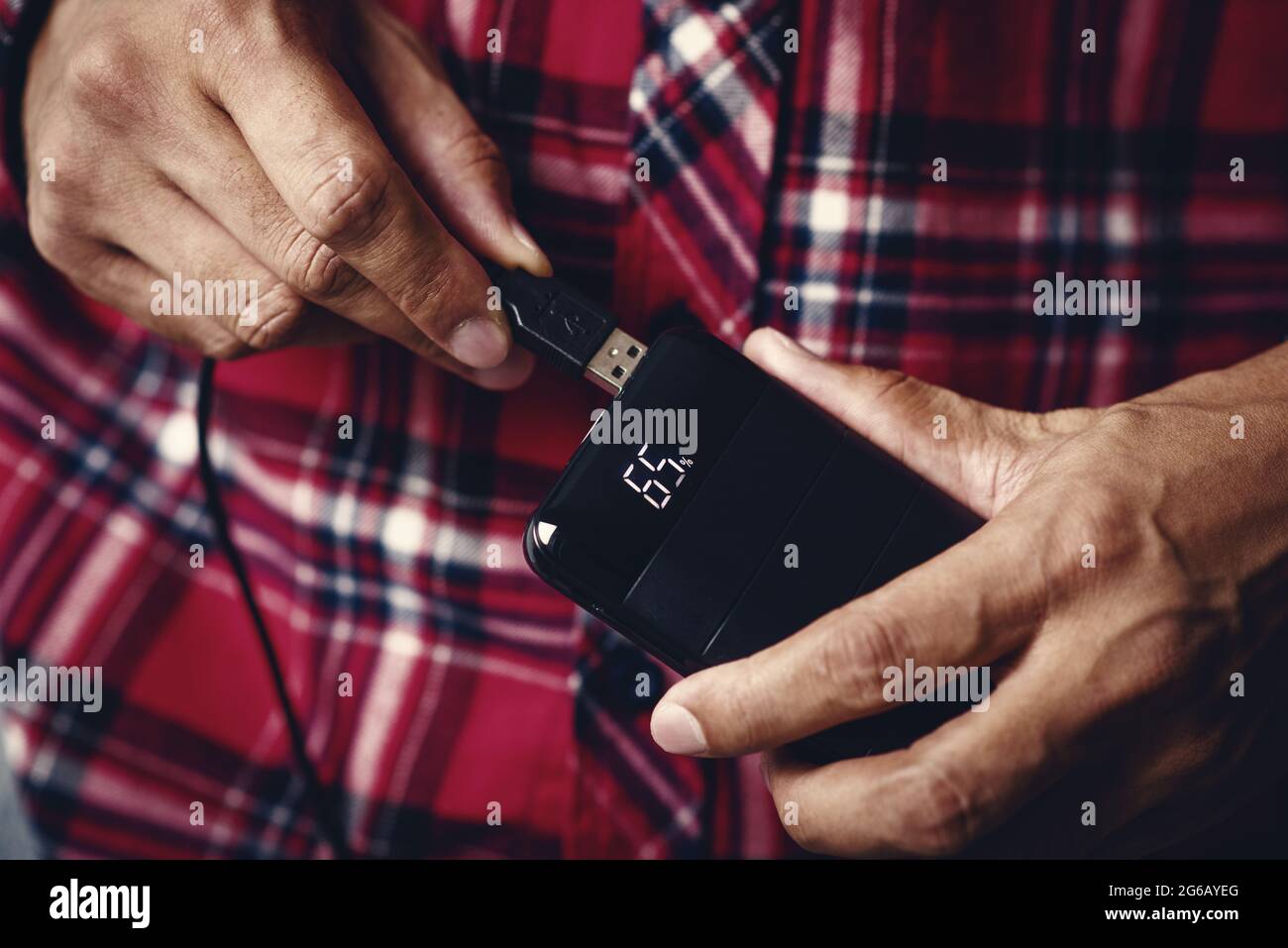The man charging his smartphone with black power bank. Shallow depth of ...