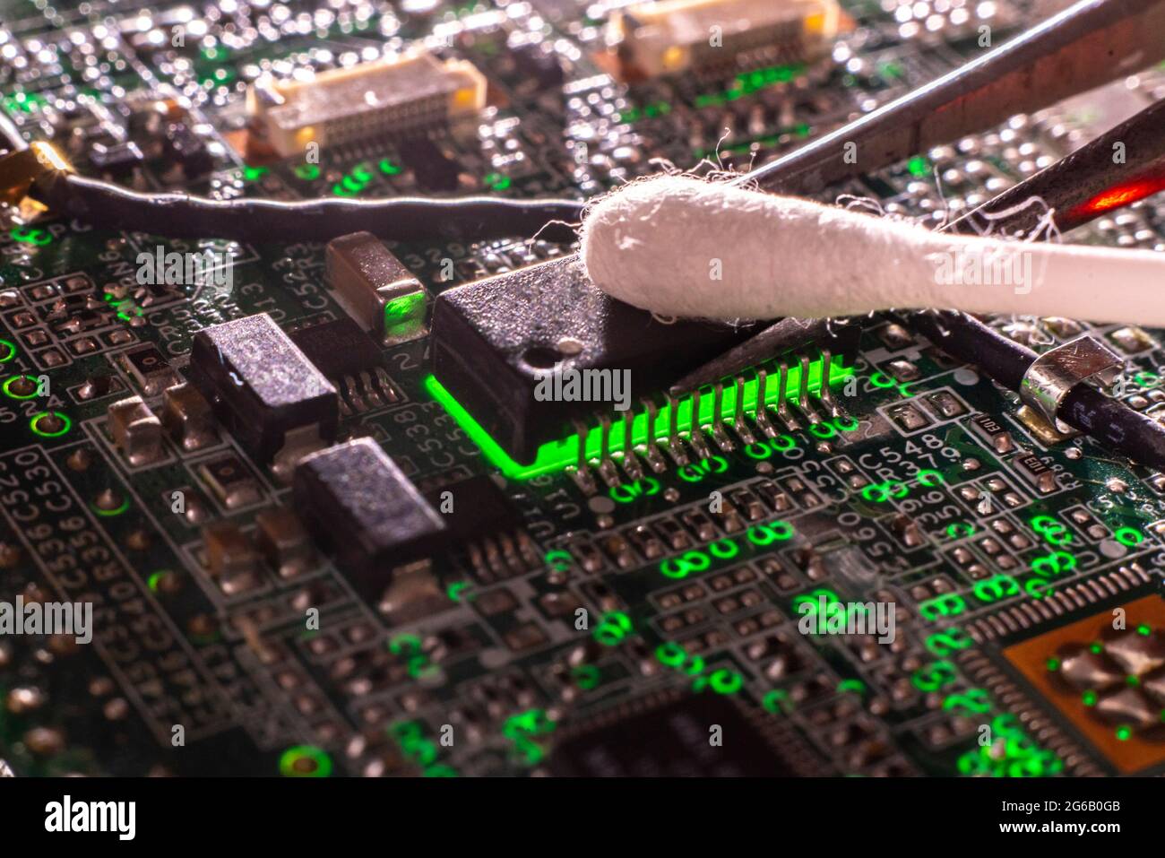 man cleaning dirty electric circuit with cotton stick macro shot of ...