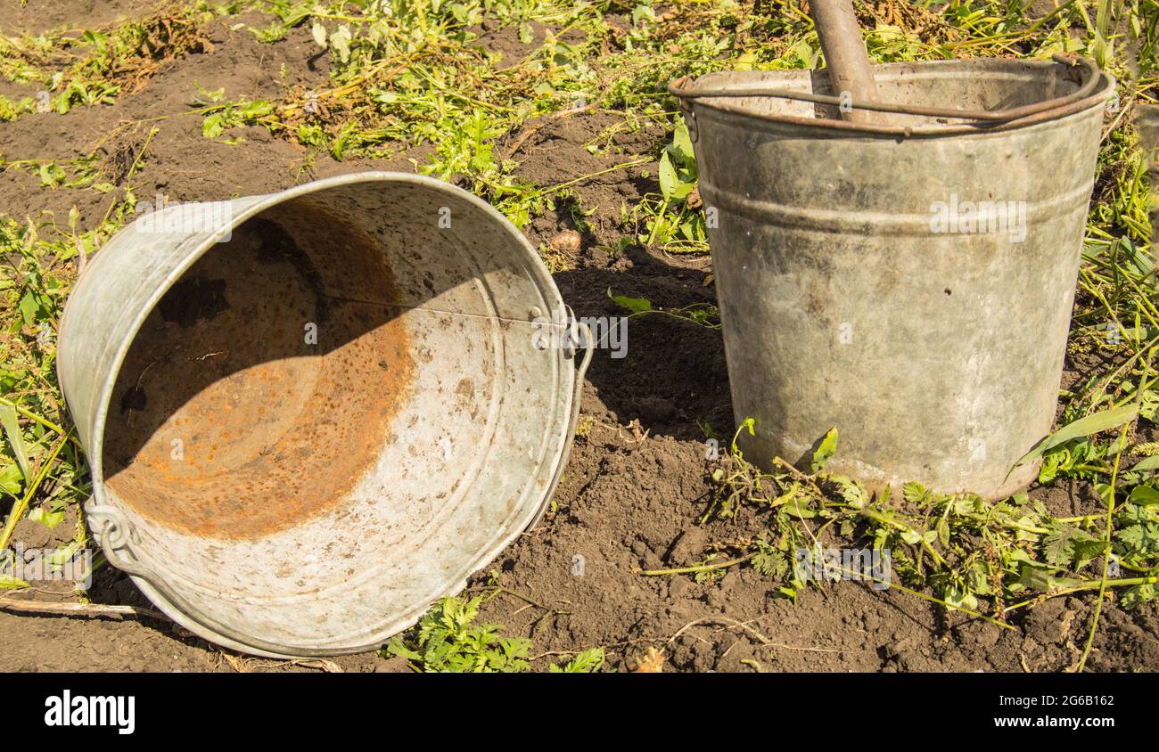 Two old, dirty, rusty, iron buckets with dirty inside and outside are ...