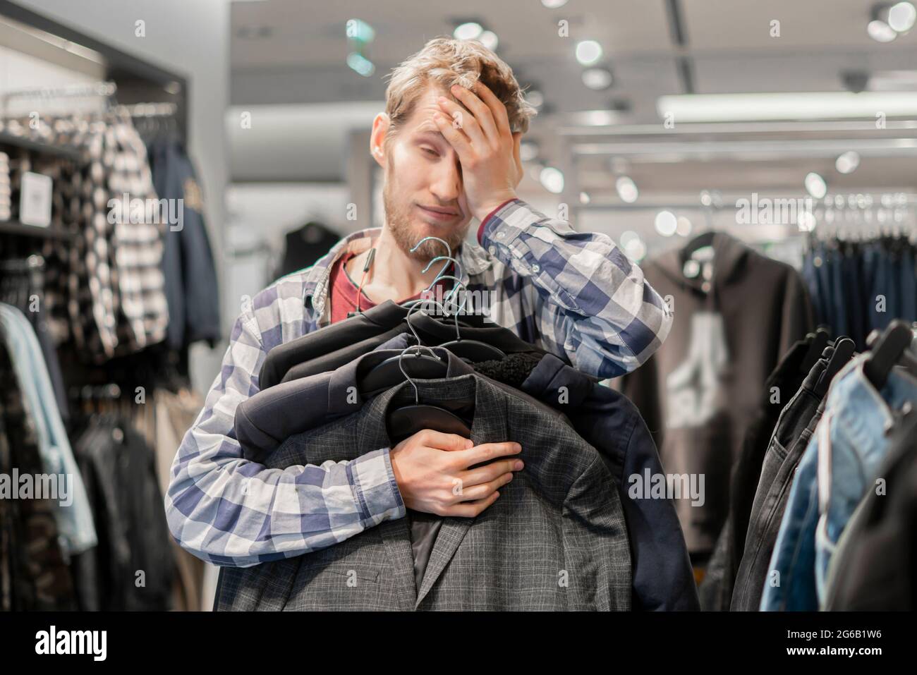 stressed person with bunch of brand new clothes in a boutique Stock ...