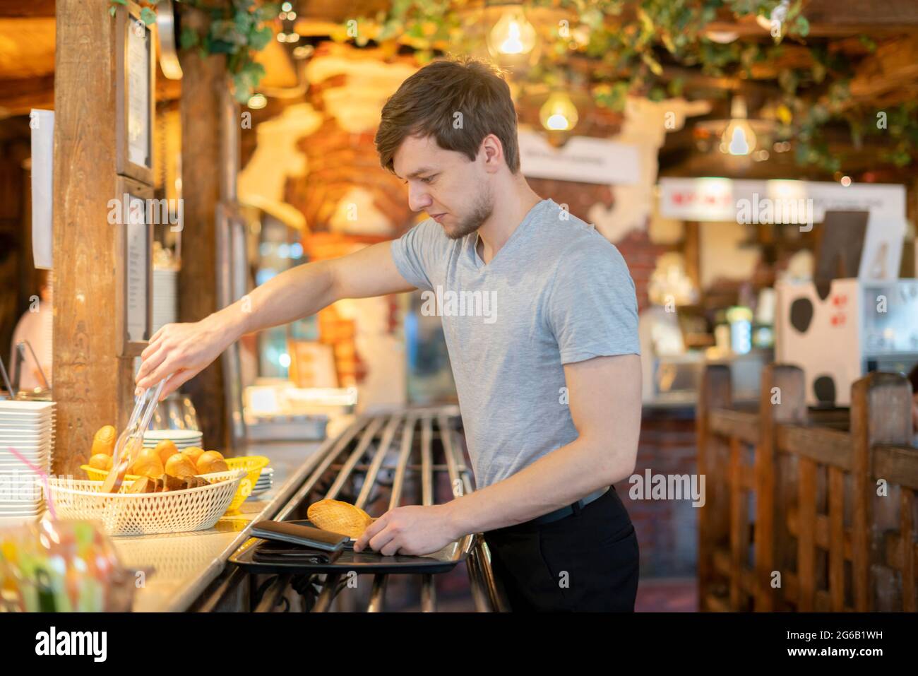 side view of young man pick breakfast ingredients in street cafe Stock ...
