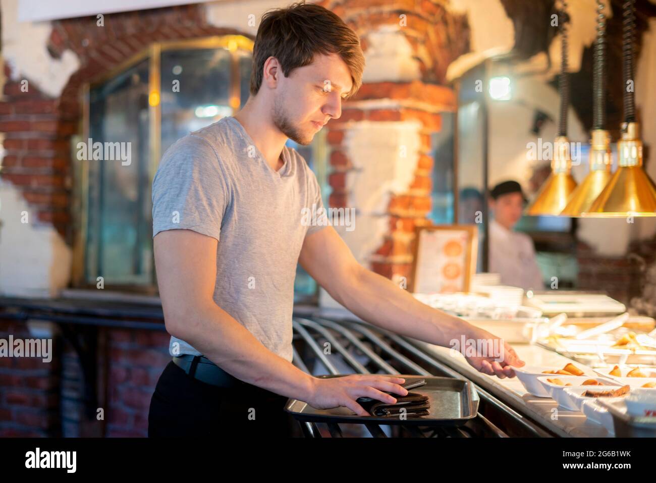 side view of young man pick breakfast ingredients in street cafe Stock ...