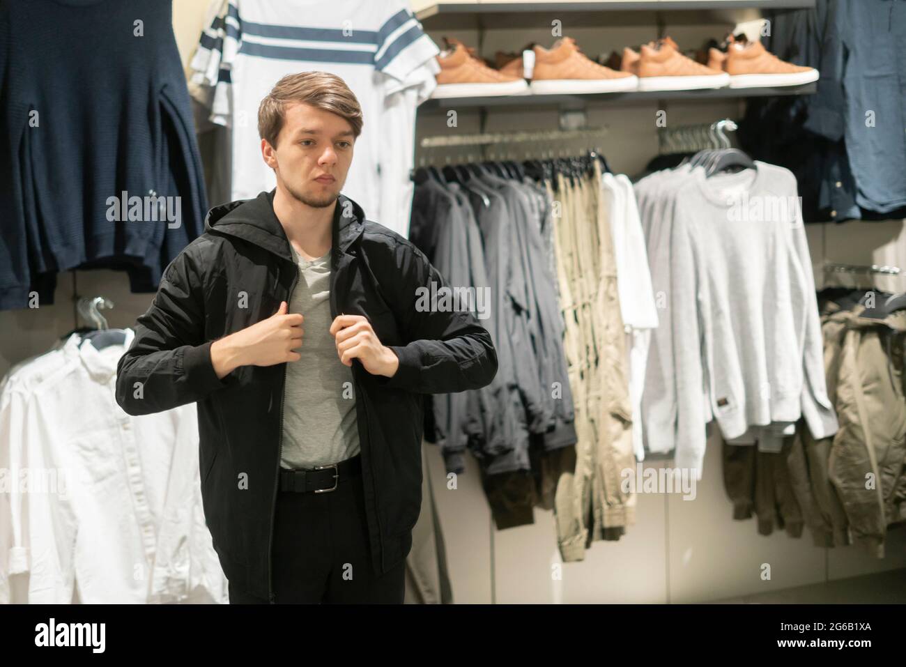 young businessman try on new jacket in the store Stock Photo - Alamy