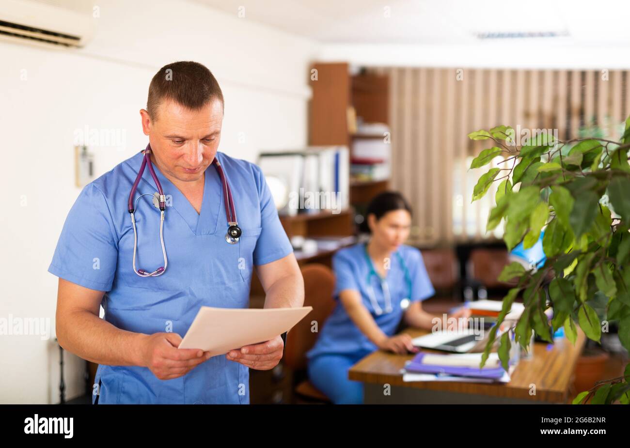 Focused doctor carefully reading patient medical cards Stock Photo - Alamy
