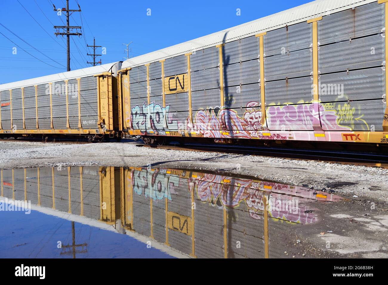 Dolton, Illinois, USA. An auto rack freight train on a curve reflected ...