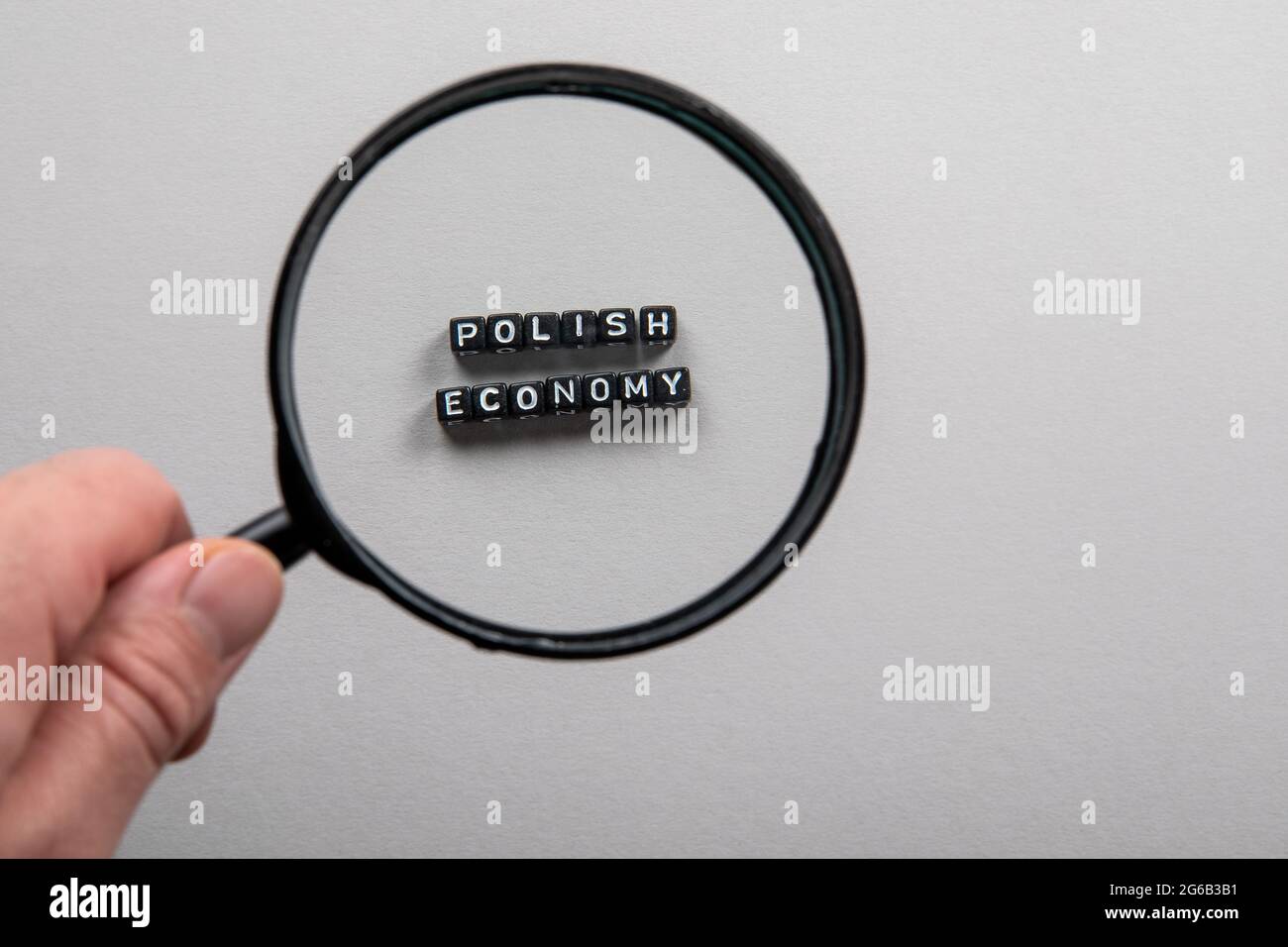 POLISH ECONOMY. Magnifying glass in a man's hand Stock Photo - Alamy