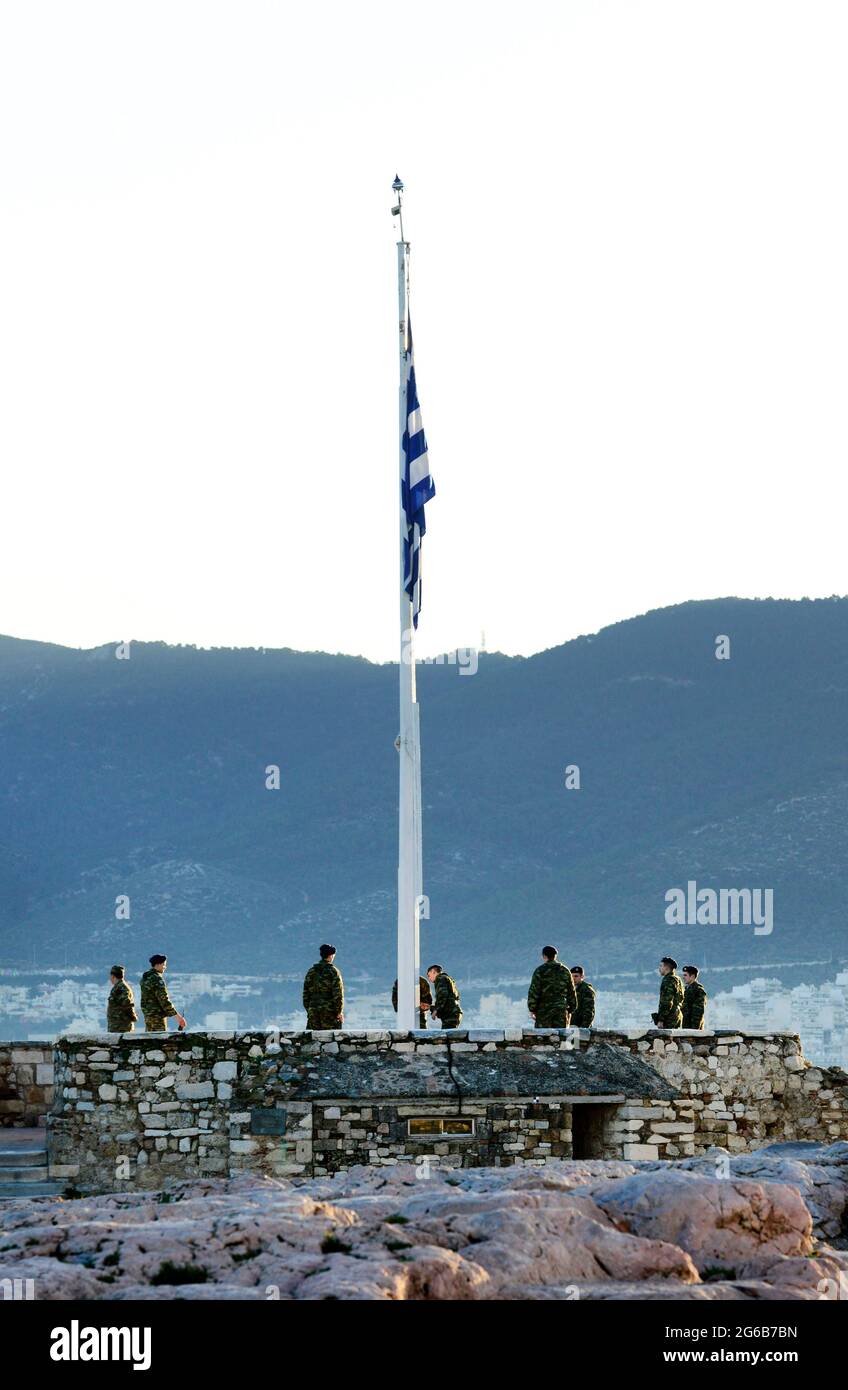Greek solders saluting the Greek flag during the early morning flag ...