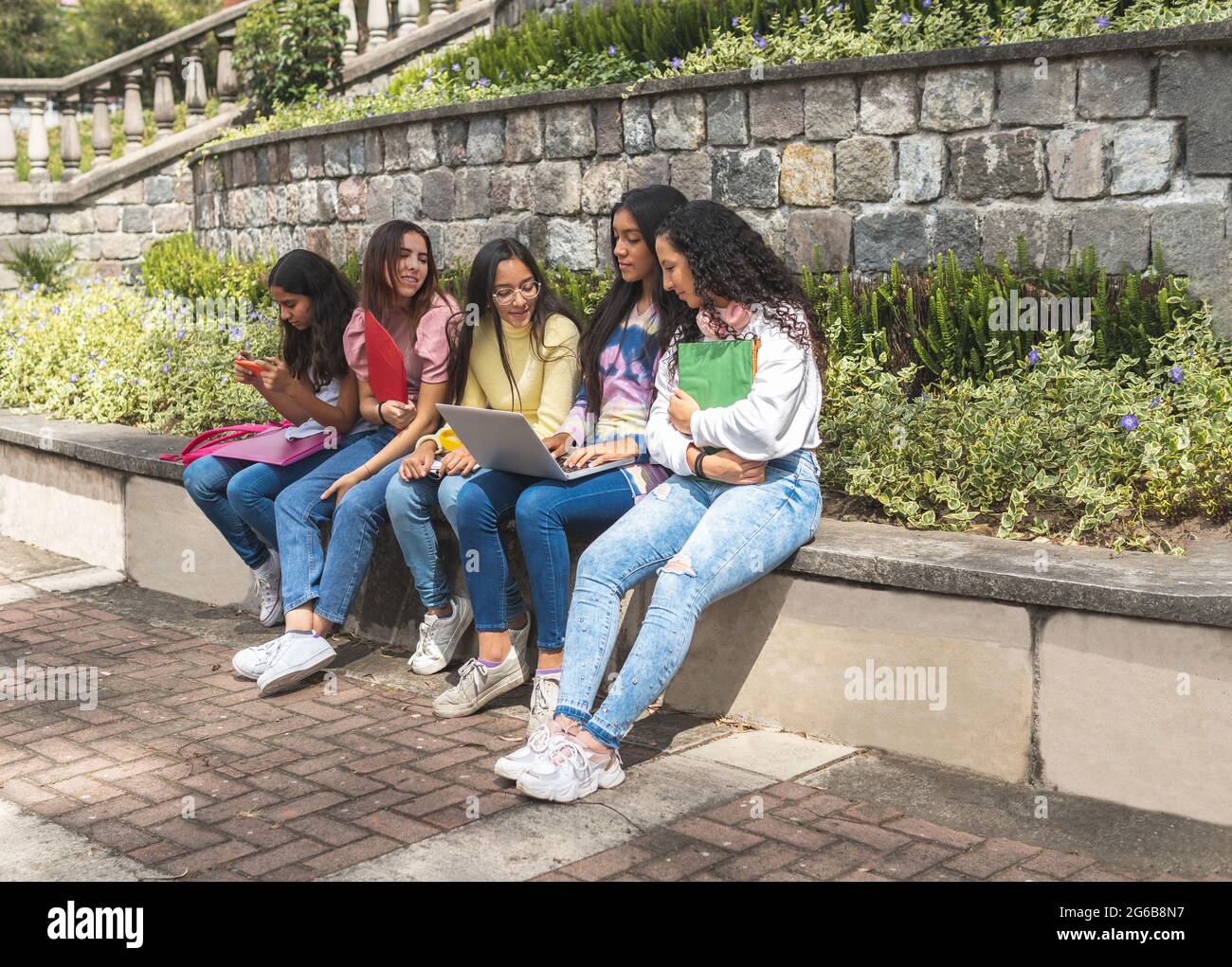 Group of Latina teenage student girls interacting with technology ...