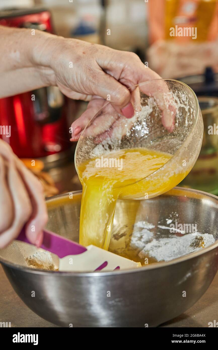 Chef pours the egg yolks into bowl for cherry pie, clafoutis. Step by ...