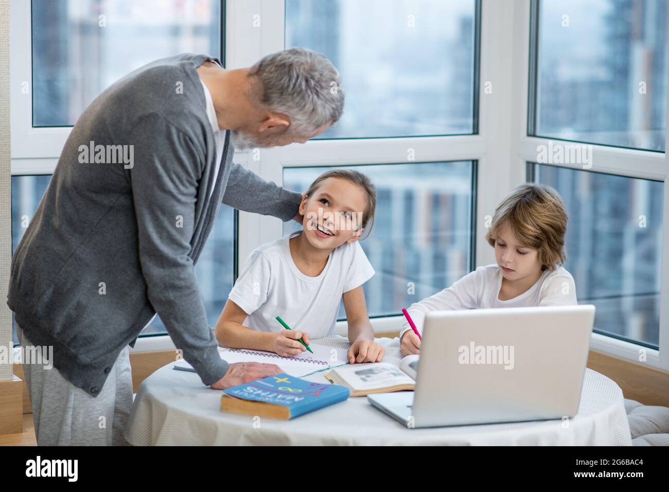 Father helping kids with lessons and explaining them something Stock ...