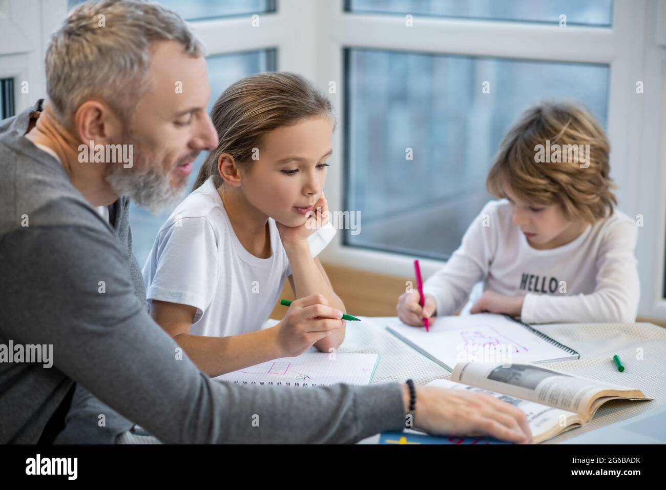 Father helping kids with lessons and explaining them something Stock ...
