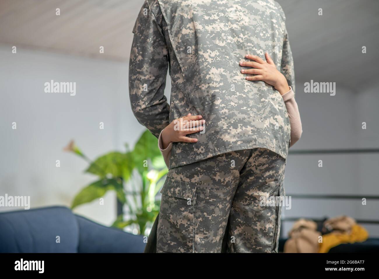 Back view of military man hugging child Stock Photo - Alamy