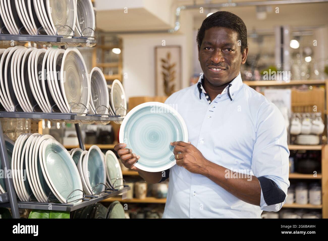 African american man chooses plates in store Stock Photo - Alamy