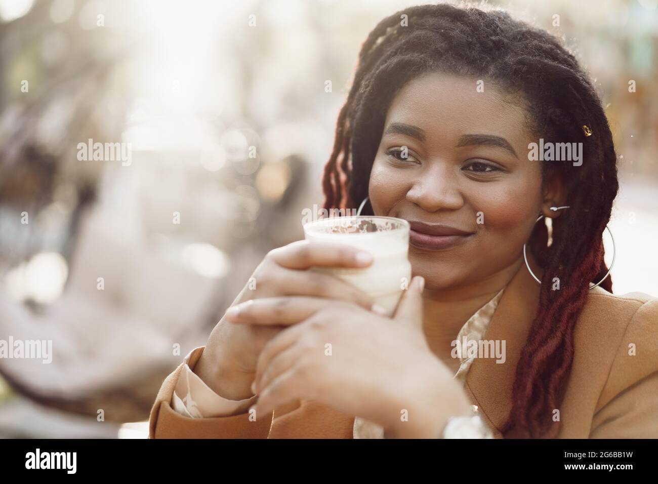 Beautiful Young African American Woman Sitting In Outdoor Cafe And
