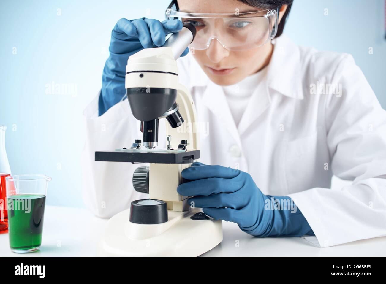 female laboratory assistant in medical gloves microscope biotechnology ...
