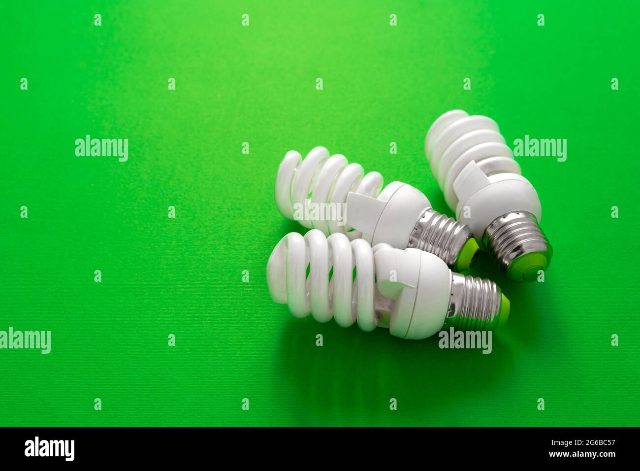 Light bulb on green paper background close up Stock Photo - Alamy
