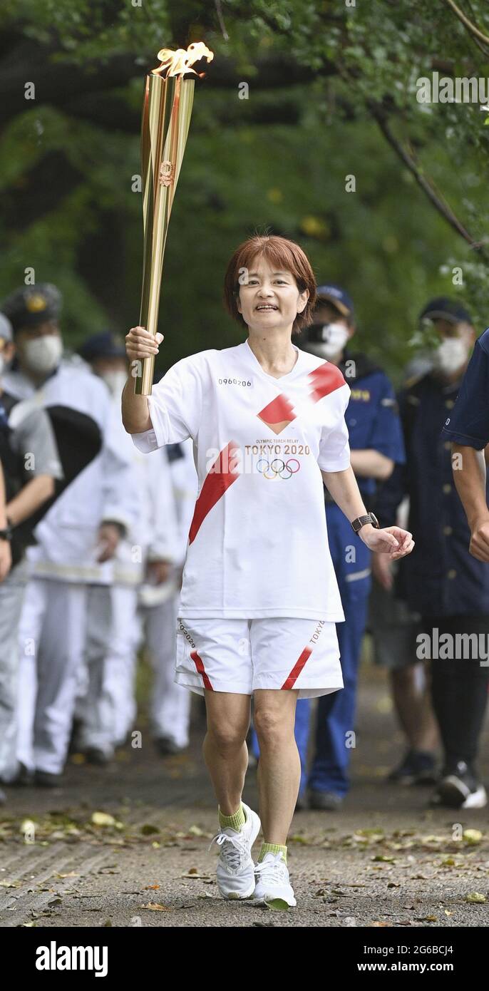 A Tokyo Olympic torch relay participant runs in the Ibaraki Prefecture ...