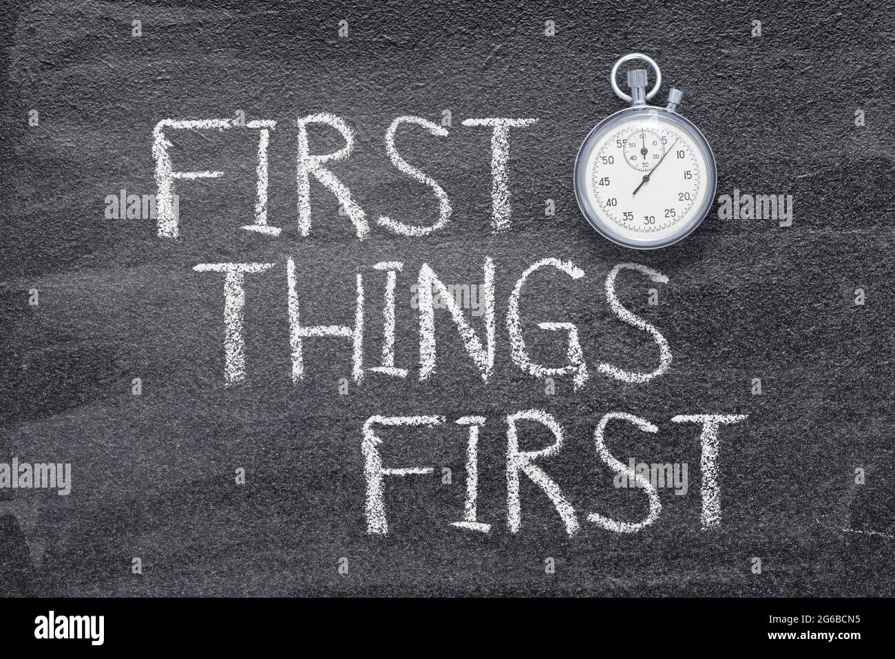 first things first phrase written on chalkboard with vintage precise ...
