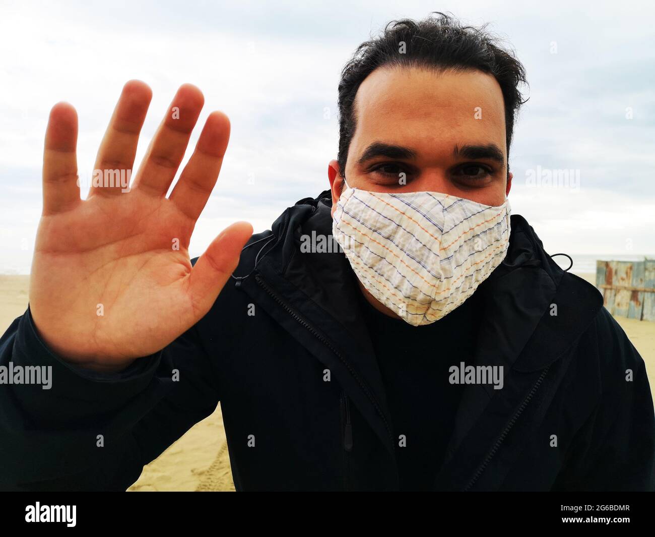 Portrait of a man wearing a protective face mask waving, Puglia, Italy ...
