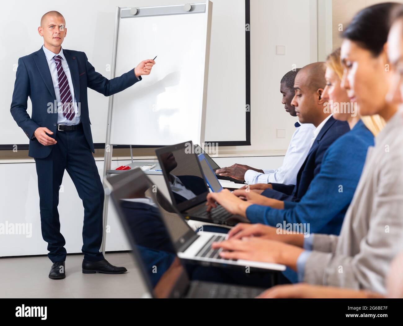 Businessman giving presentation to partners at meeting Stock Photo - Alamy