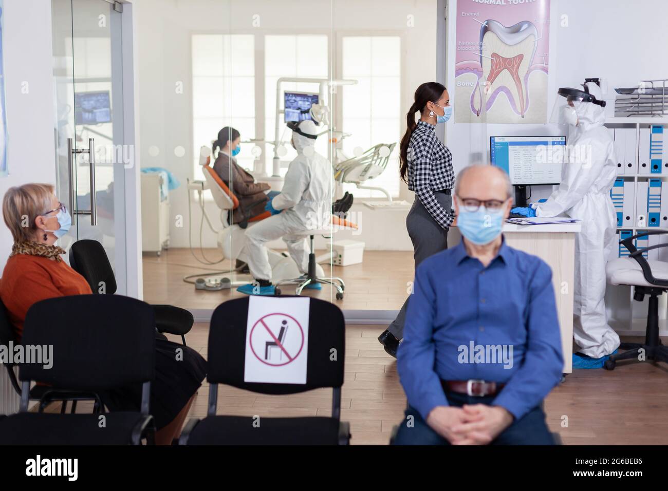 Dentist nurse dressed in ppe suit with face shiled discussing with ...