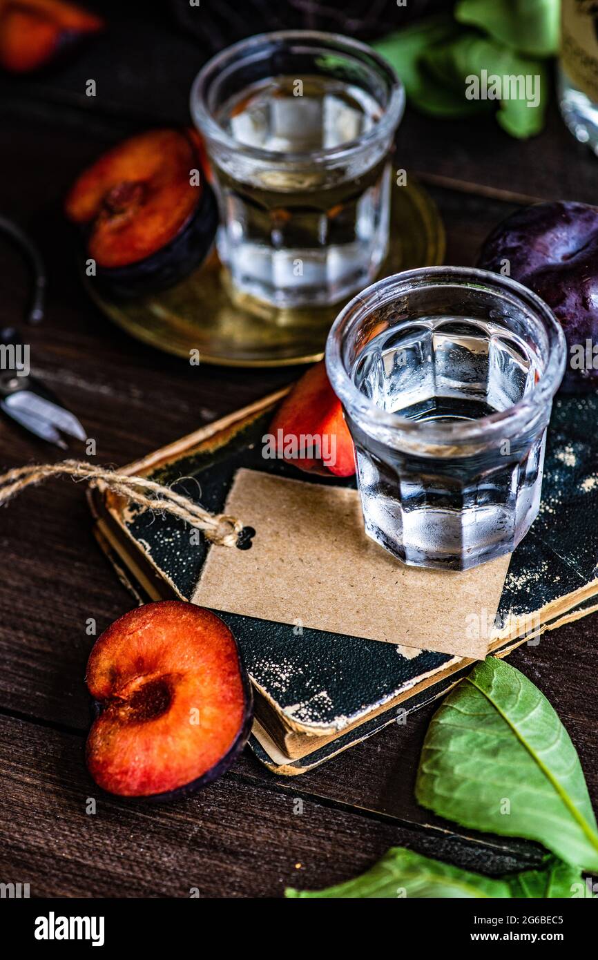 Two glasses of plum vodka on a table with fresh plums Stock Photo - Alamy