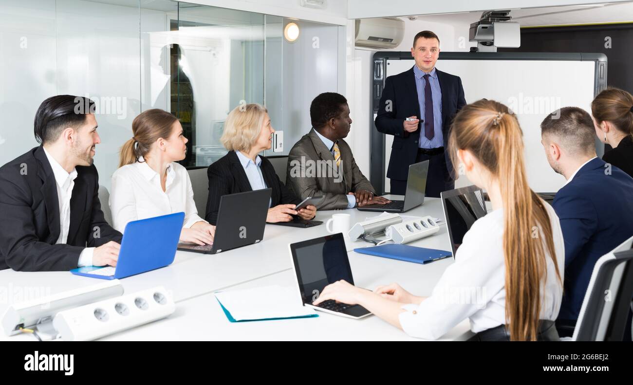 Businessman speaker making presentation to group Stock Photo - Alamy