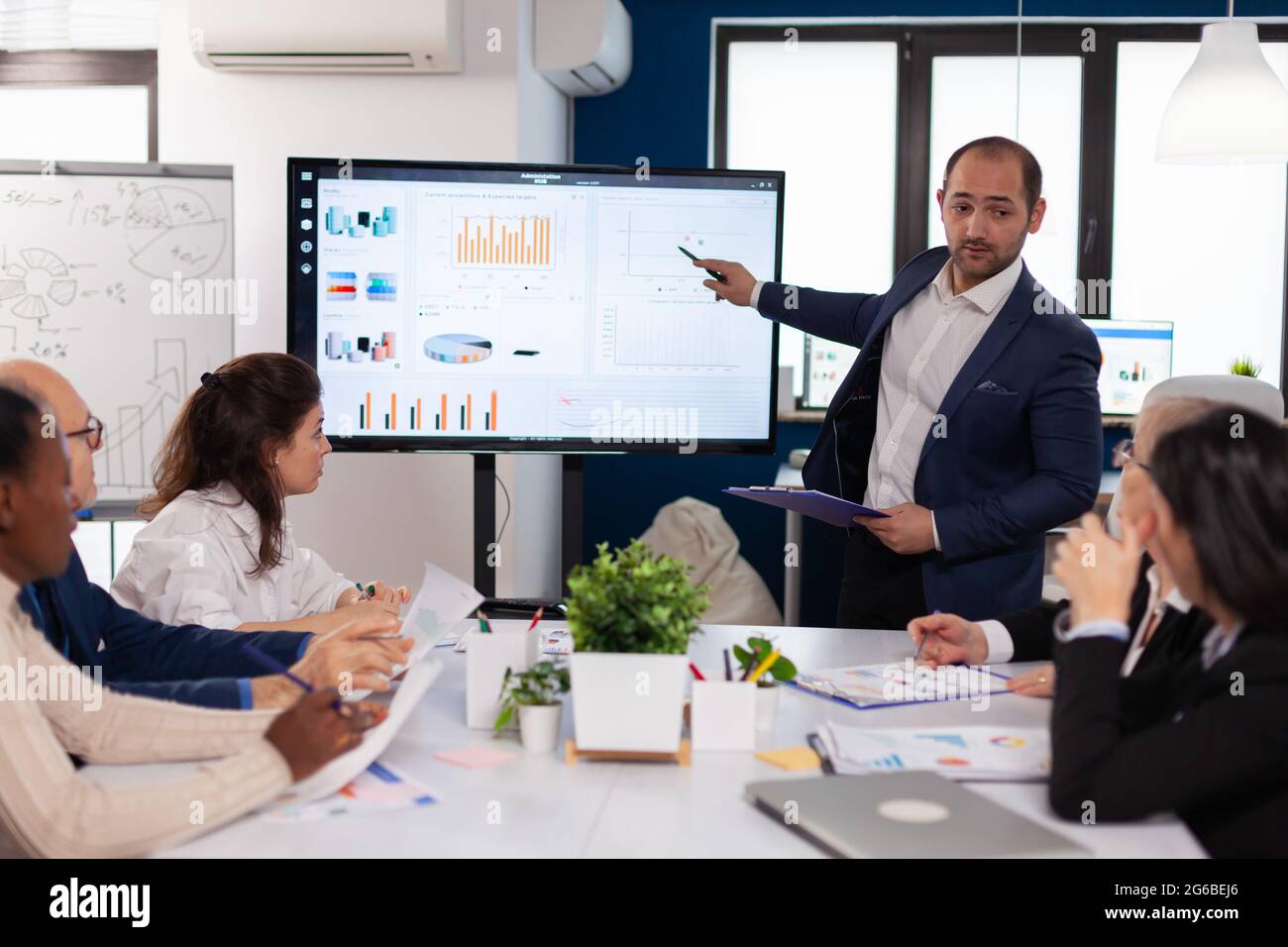 Manager holding briefing presentation in conference room monitor ...