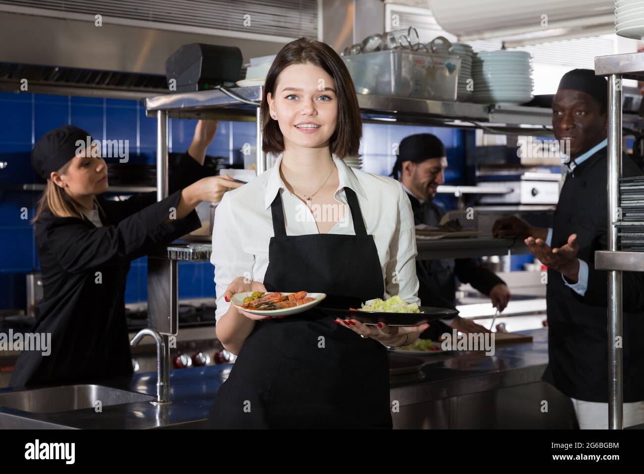 Waitress with dishes in kitchen Stock Photo - Alamy
