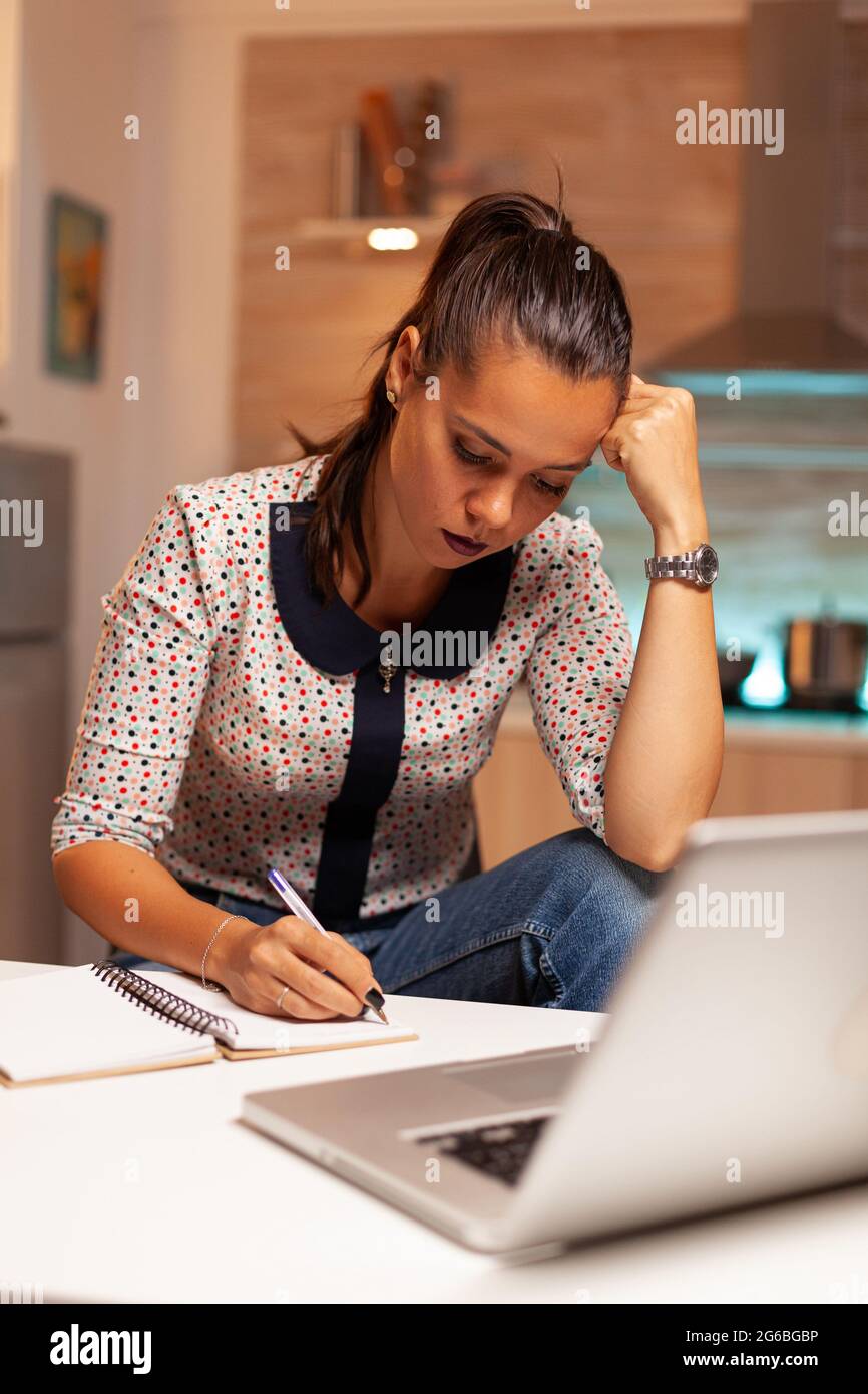 Concentrated freelance woman working overtime to finish a project from ...