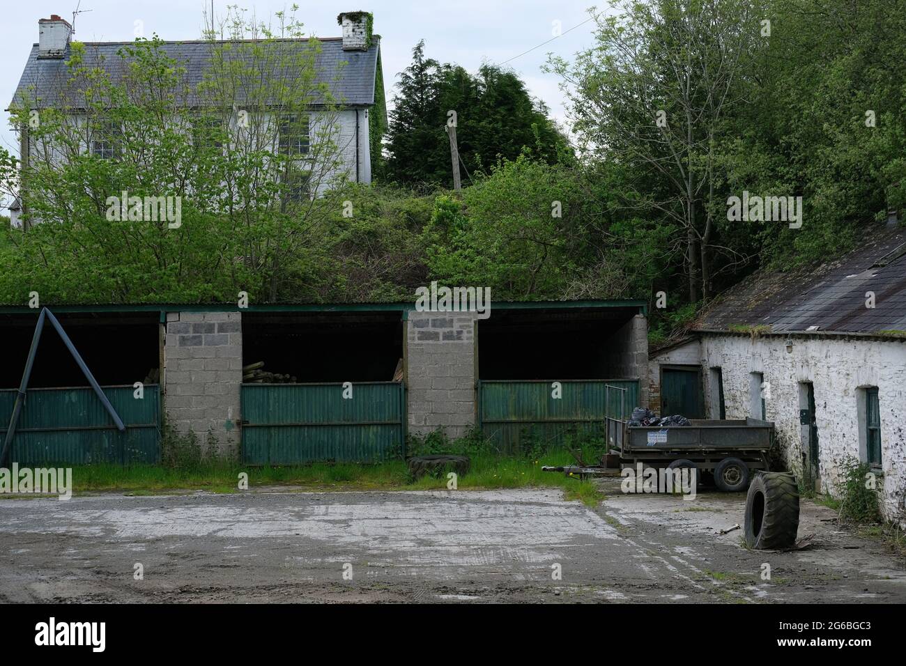 Derelict Farm with outbuildings, trailer and large tractor tyre Stock ...