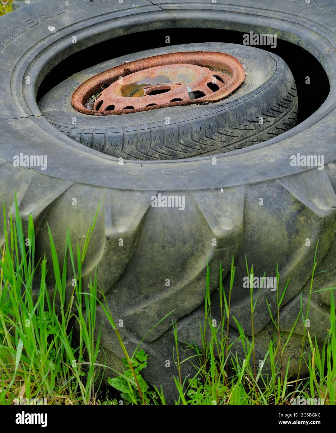 Car wheel inside a tractor tyre / tire Stock Photo - Alamy