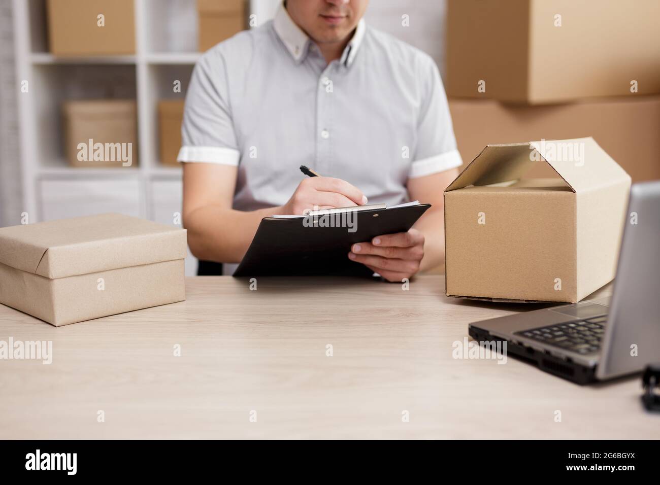 work, business and delivery concept - close up of postman hands writing ...