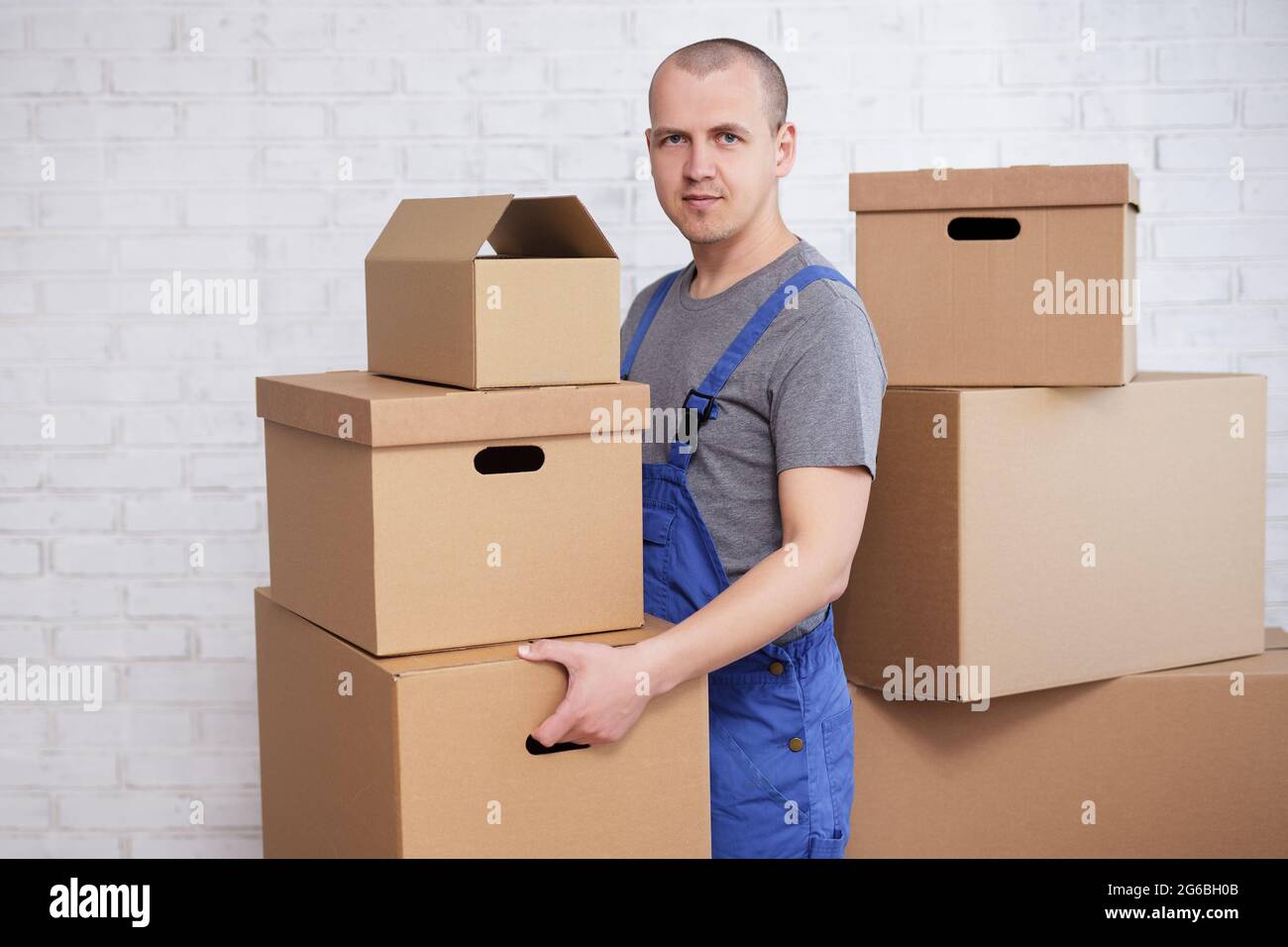 handsome man loader or deliveryman holding many boxes Stock Photo - Alamy