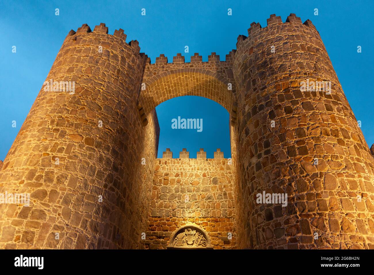 Alcazar Gate of the medieval city wall of Avila at dusk, Spain Stock ...