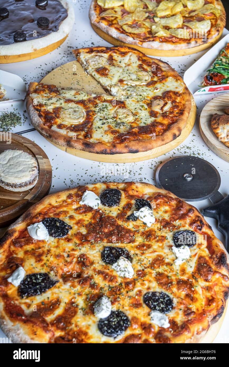 Variety of pizzas on the restaurant table to eat. Vertical picture ...
