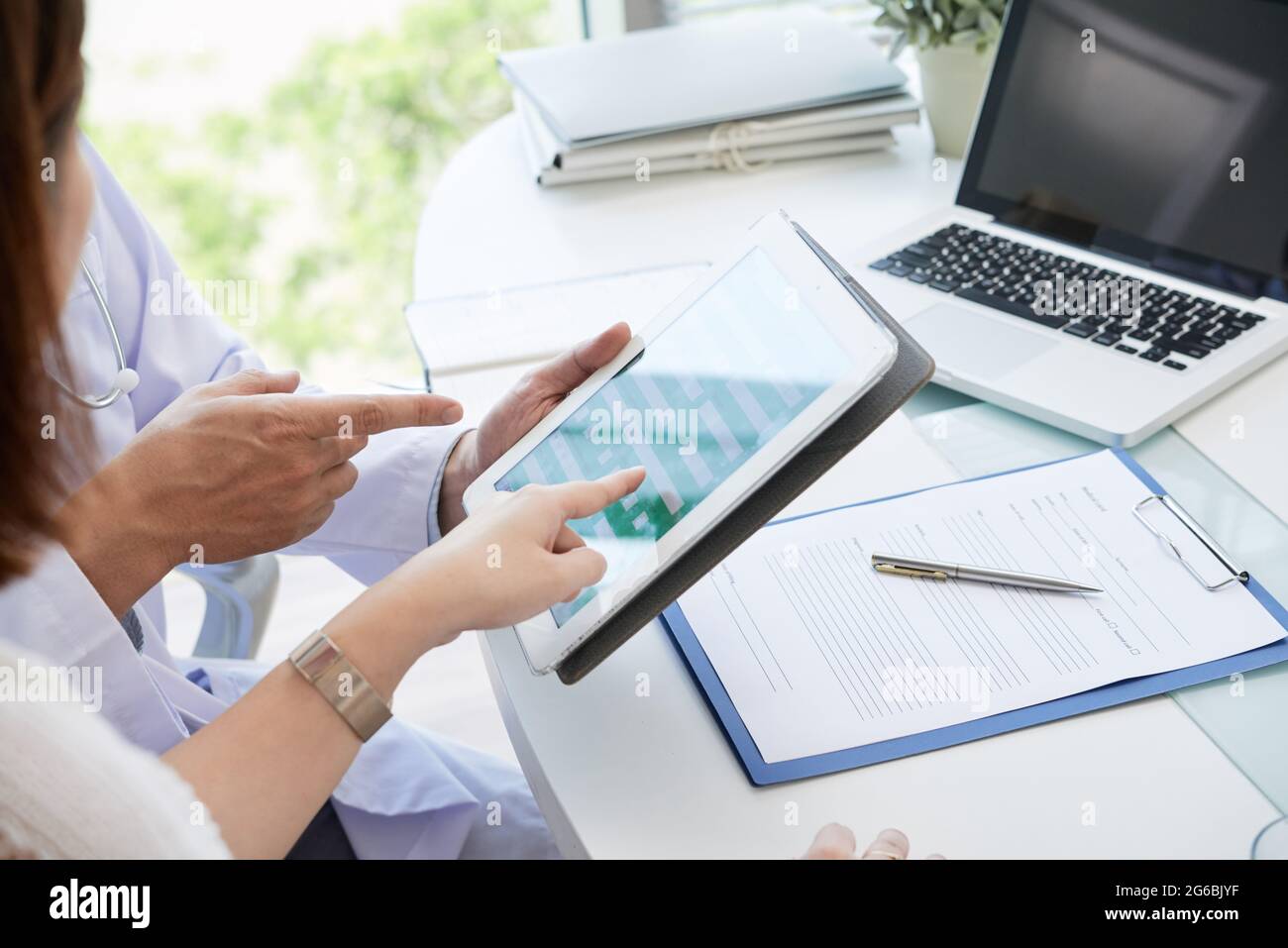 Doctor explaining patient how to fill personal data in form on digital ...