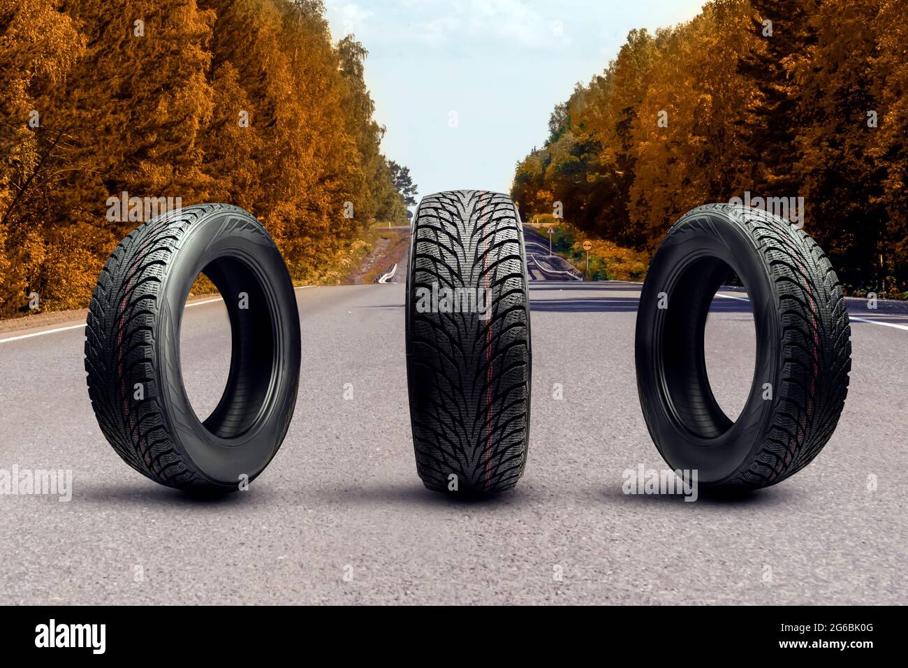three winter tires on an autumn road. upcoming seasonal tire ...