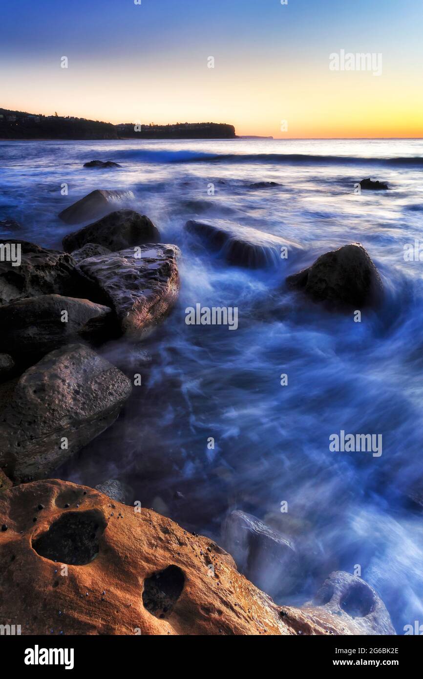 Sandstone rocks and boulders on Newport beach of Sydney - facing rising ...