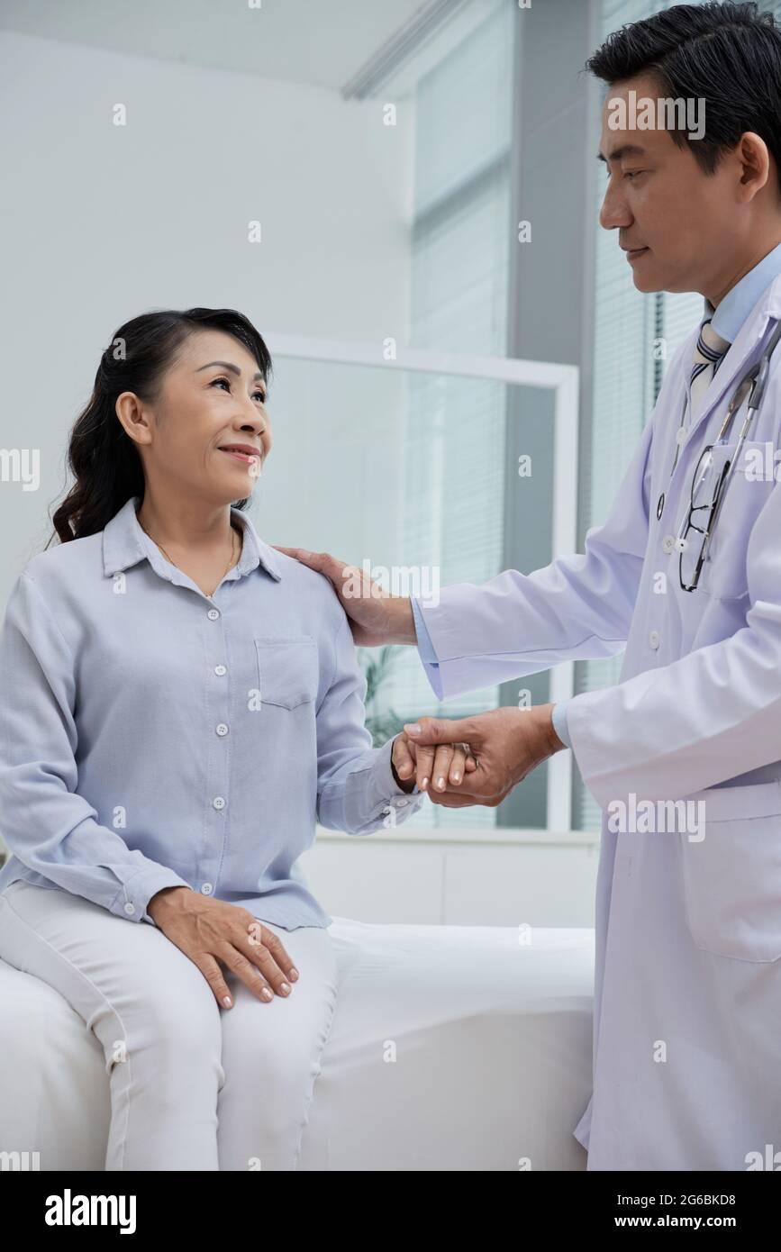 Doctor reassuring female senior patient after annual examination and ...