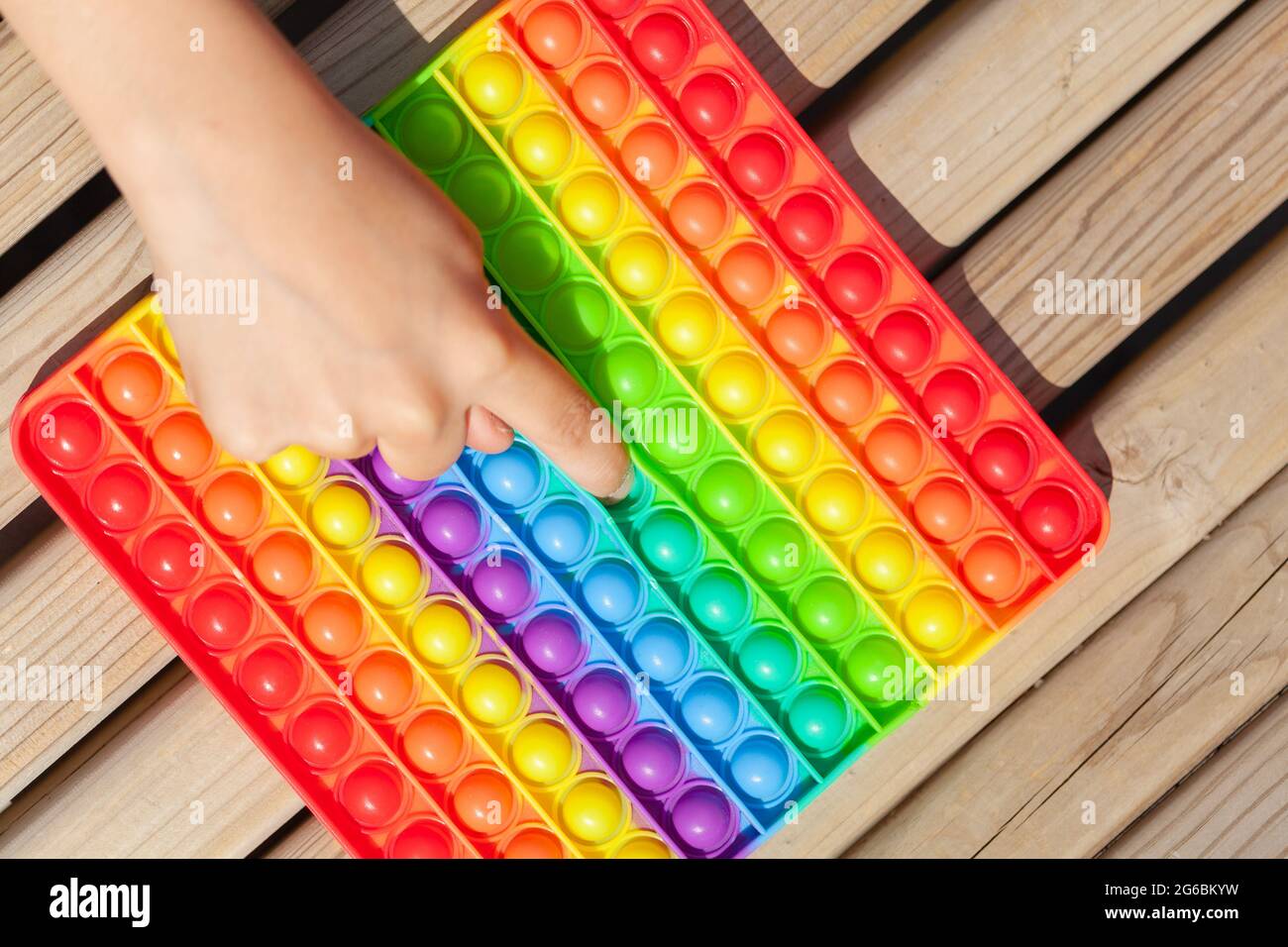 Baby fingers and antistress toy - popit, simple dimple Stock Photo - Alamy