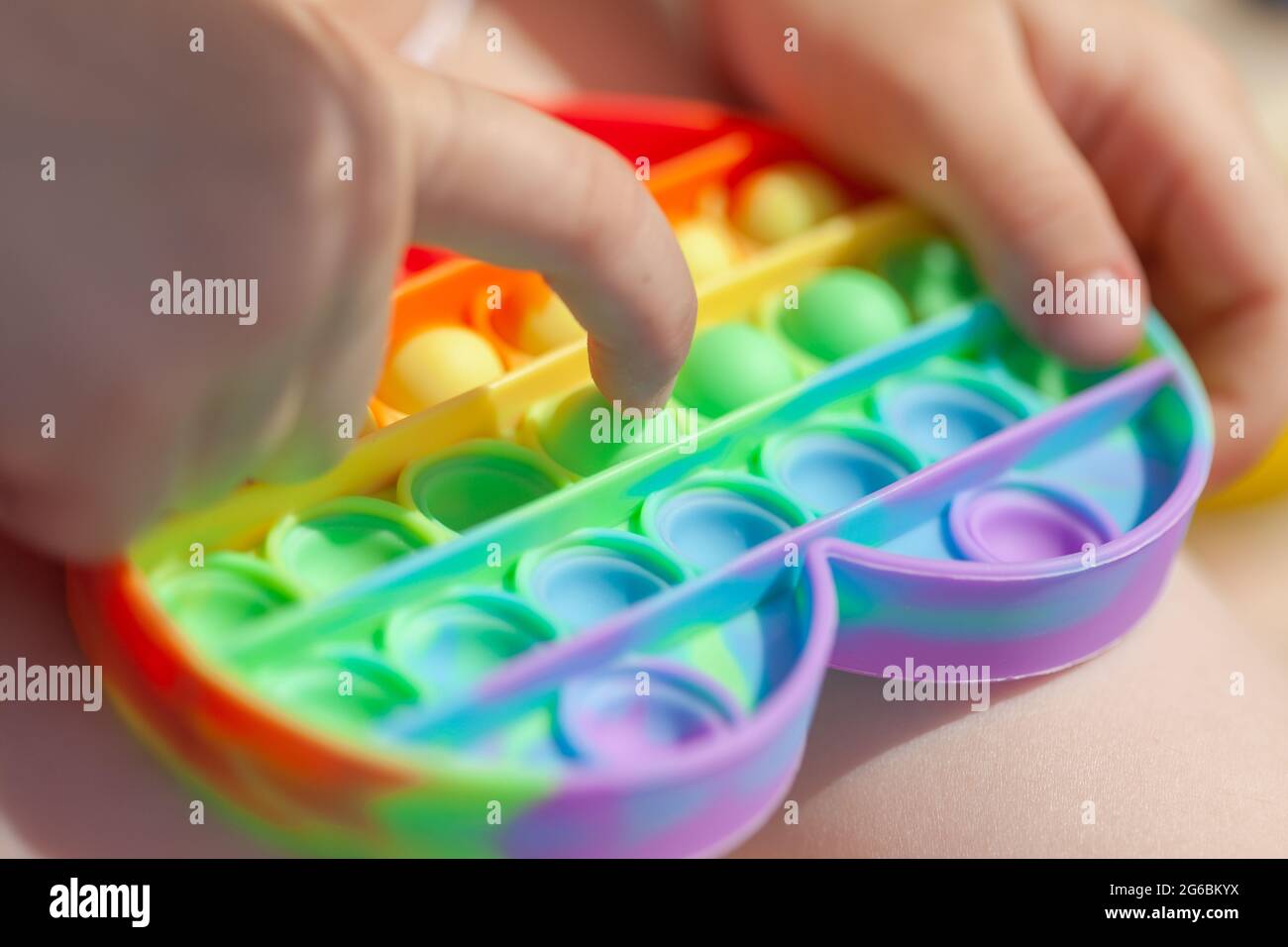 Baby fingers and antistress toy - popit, simple dimple Stock Photo - Alamy